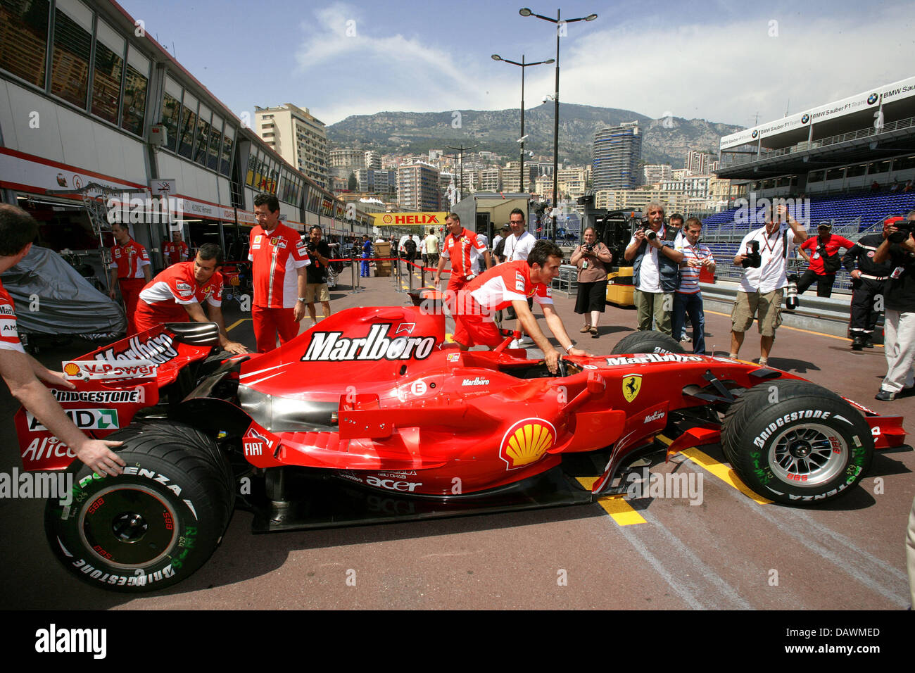 I meccanici della scuderia Ferrari spingere indietro una vettura da ...