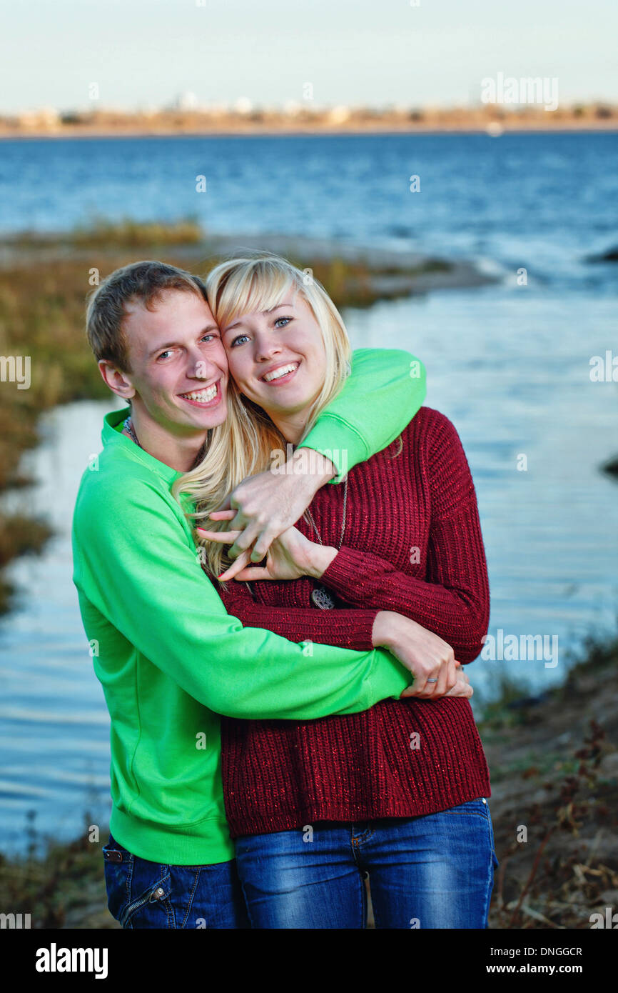 Coppia giovane con tenerezza e amore abbracciare ogni altro sulle rive del fiume Foto stock - Alamy