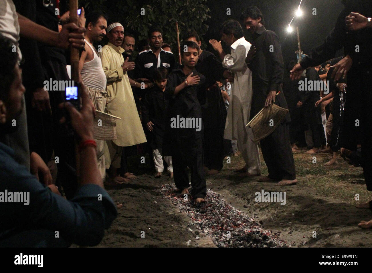 Pakistano musulmano sciita passeggiate sui carboni bruciati al settimo giorno di Muharram come ...