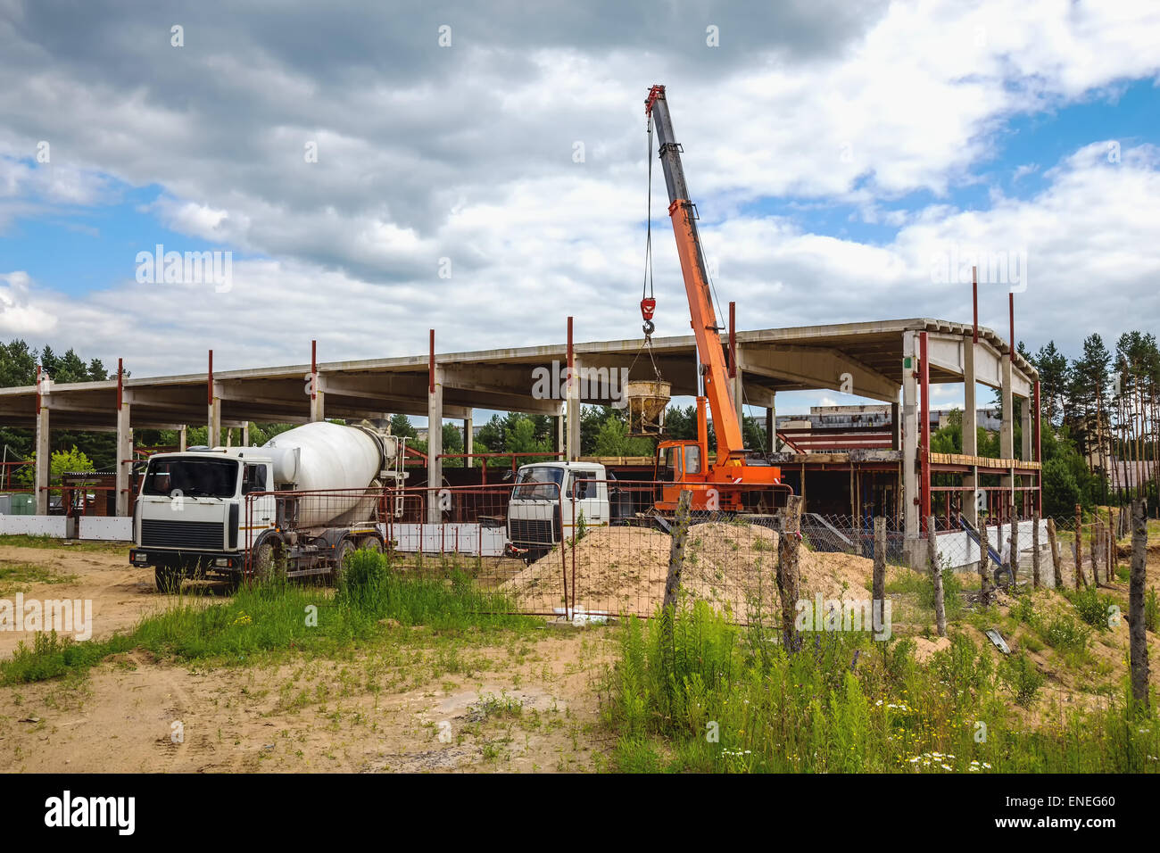 Edificio in costruzione presso un cantiere con gru e la betoniera Foto ...