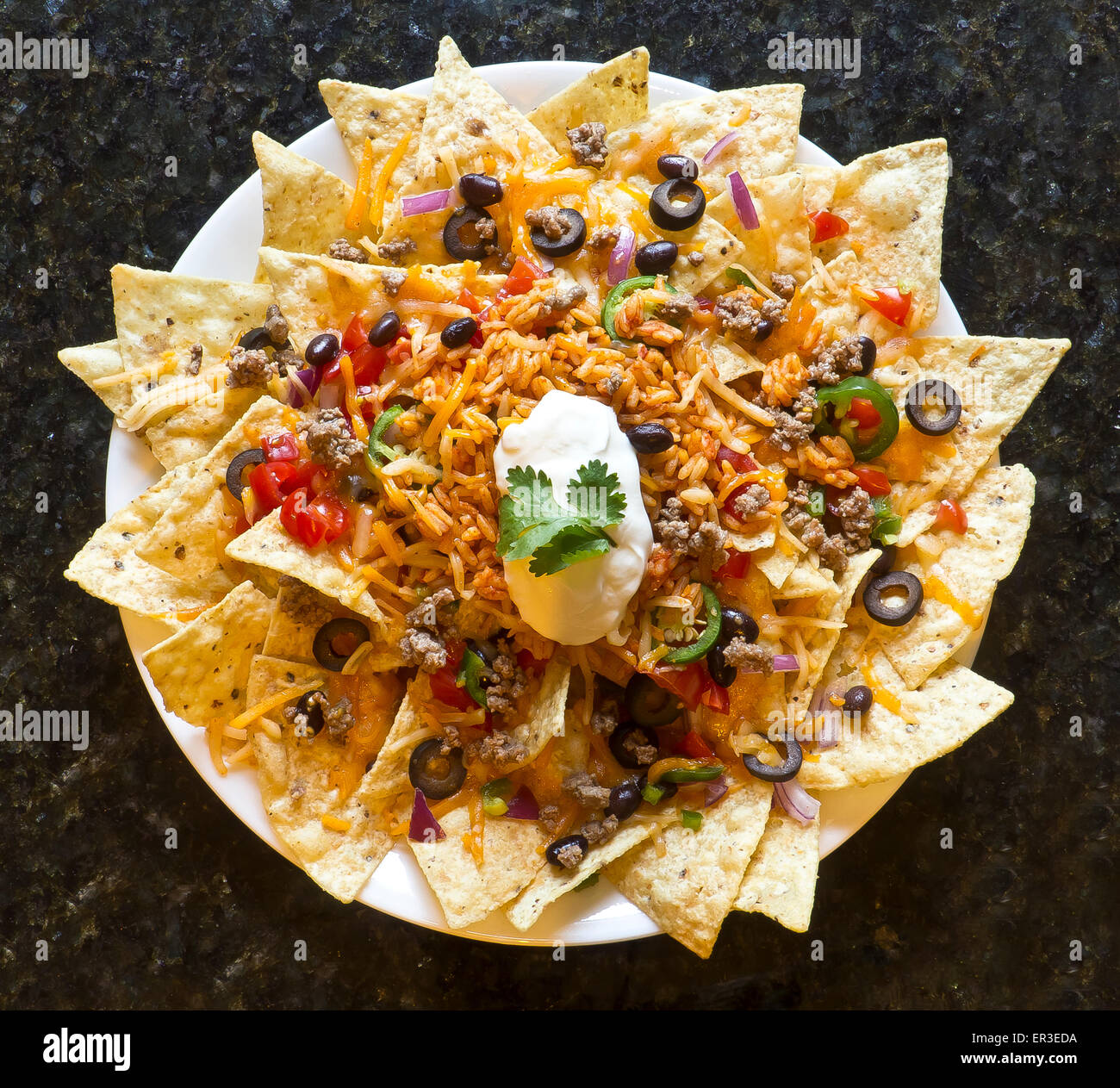 Mexican nachos con panna acida, olive nere, carne di manzo macinata ...