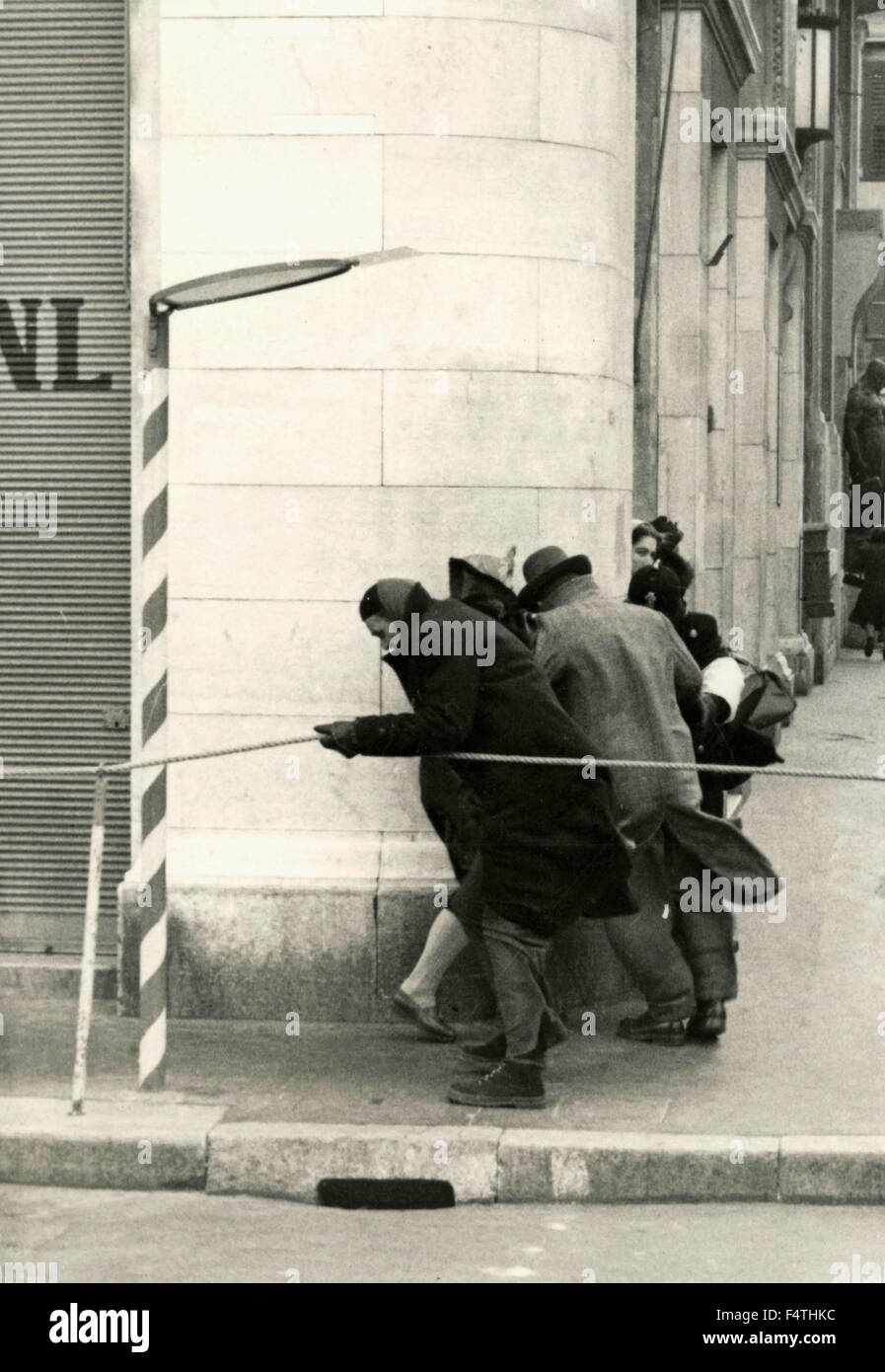 Passanti a tenere una fune a causa del vento di bora a Trieste, Italia ...