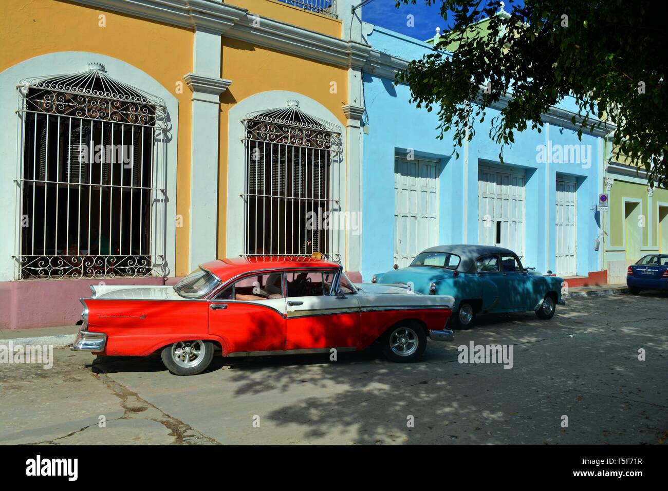 Auto d'epoca parcheggiata fuori edifici color pastello in Trinidad Cuba ...