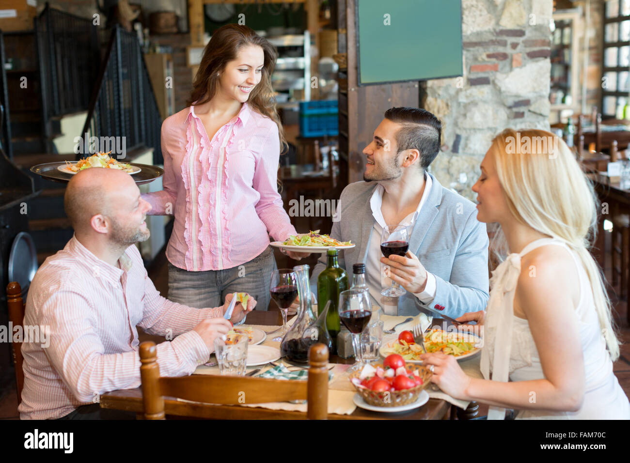Allegro gruppo di persone aventi la cena al ristorante rurale. Focus ...