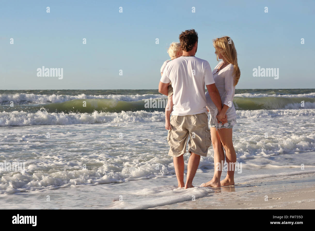 Una famiglia felice di tre persone comprese, madre, padre e figlio in ...