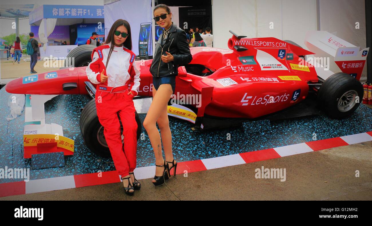 Modelli cinesi in posa di fronte di auto da corsa in auto in mostra a ...