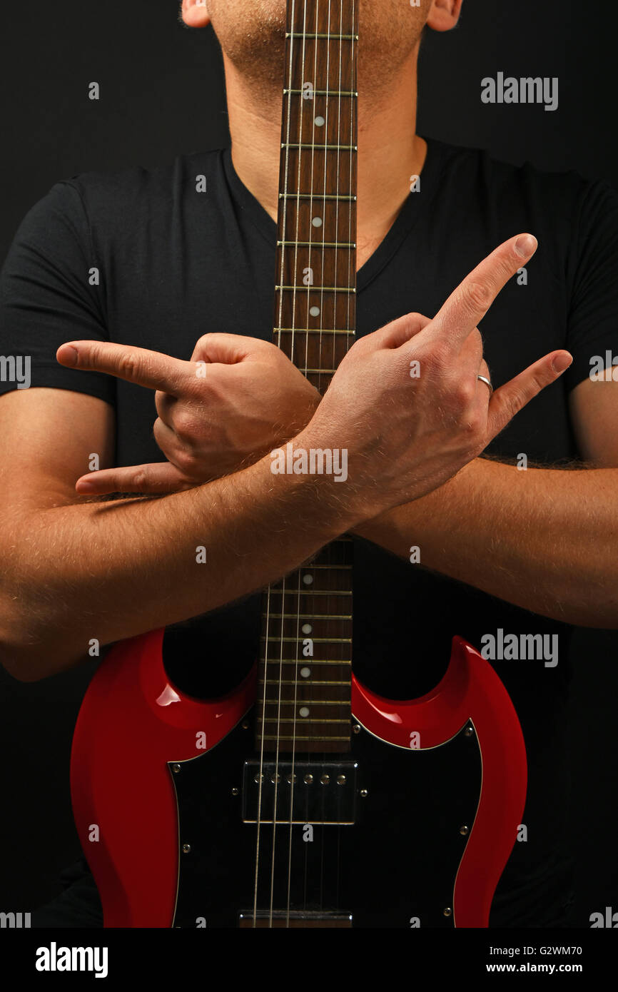L'uomo azienda abbracciando red sg guitar collo con due mani che mostra ...