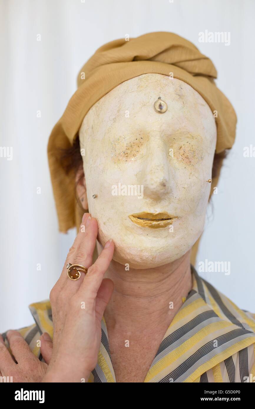Una persona che indossa una maschera di un volto di donna senza occhi ... Una persona che indossa una maschera di un volto di donna senza occhi ...