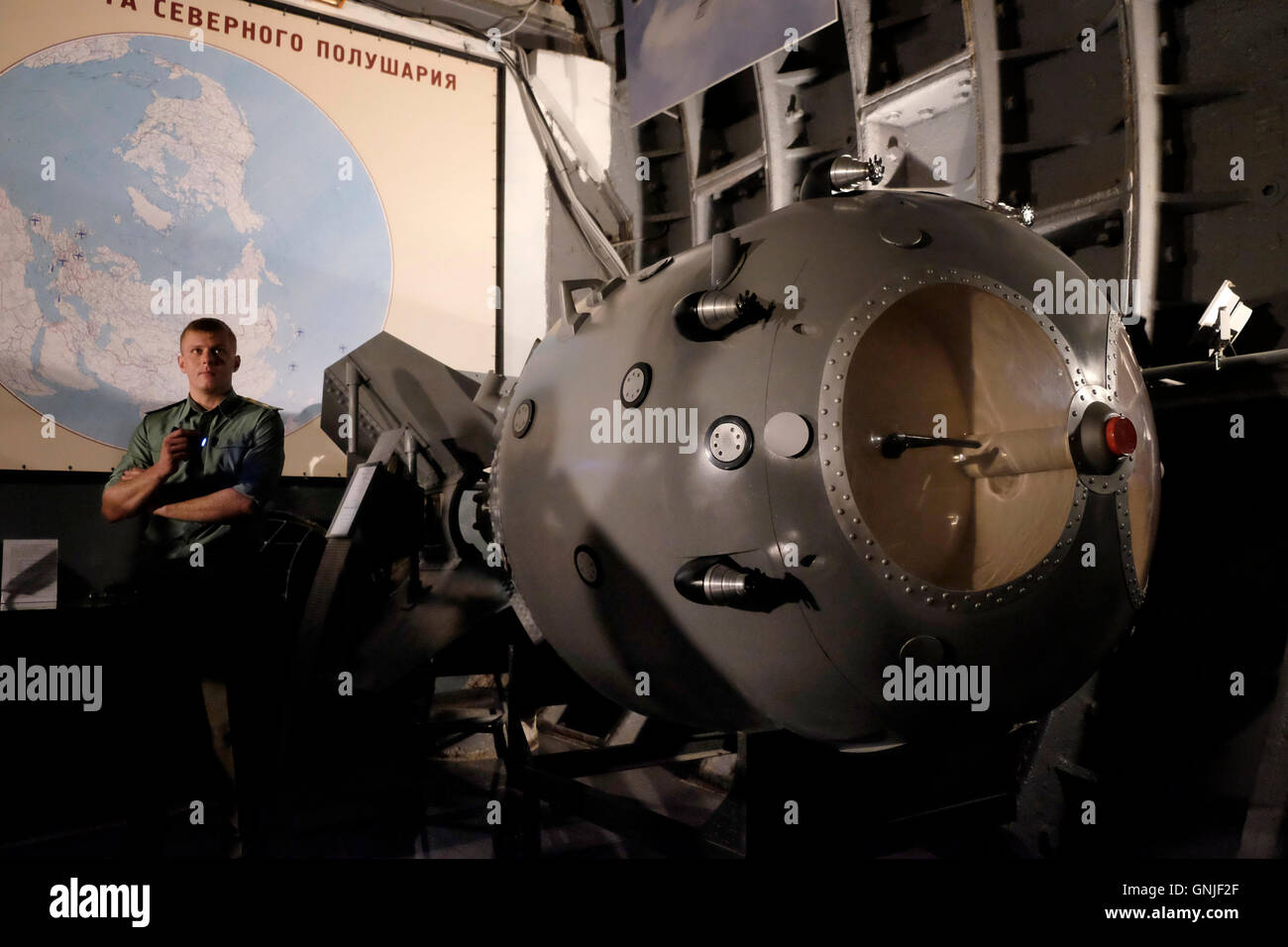Una guida russa in uniforme si trova accanto alla prima bomba atomica ...