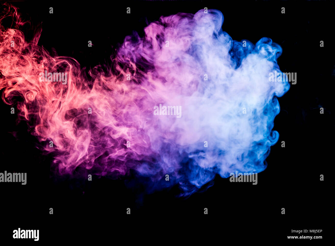Fumo colorato di rosa e blu su un isolato nero lo sfondo. Sfondo dal ...