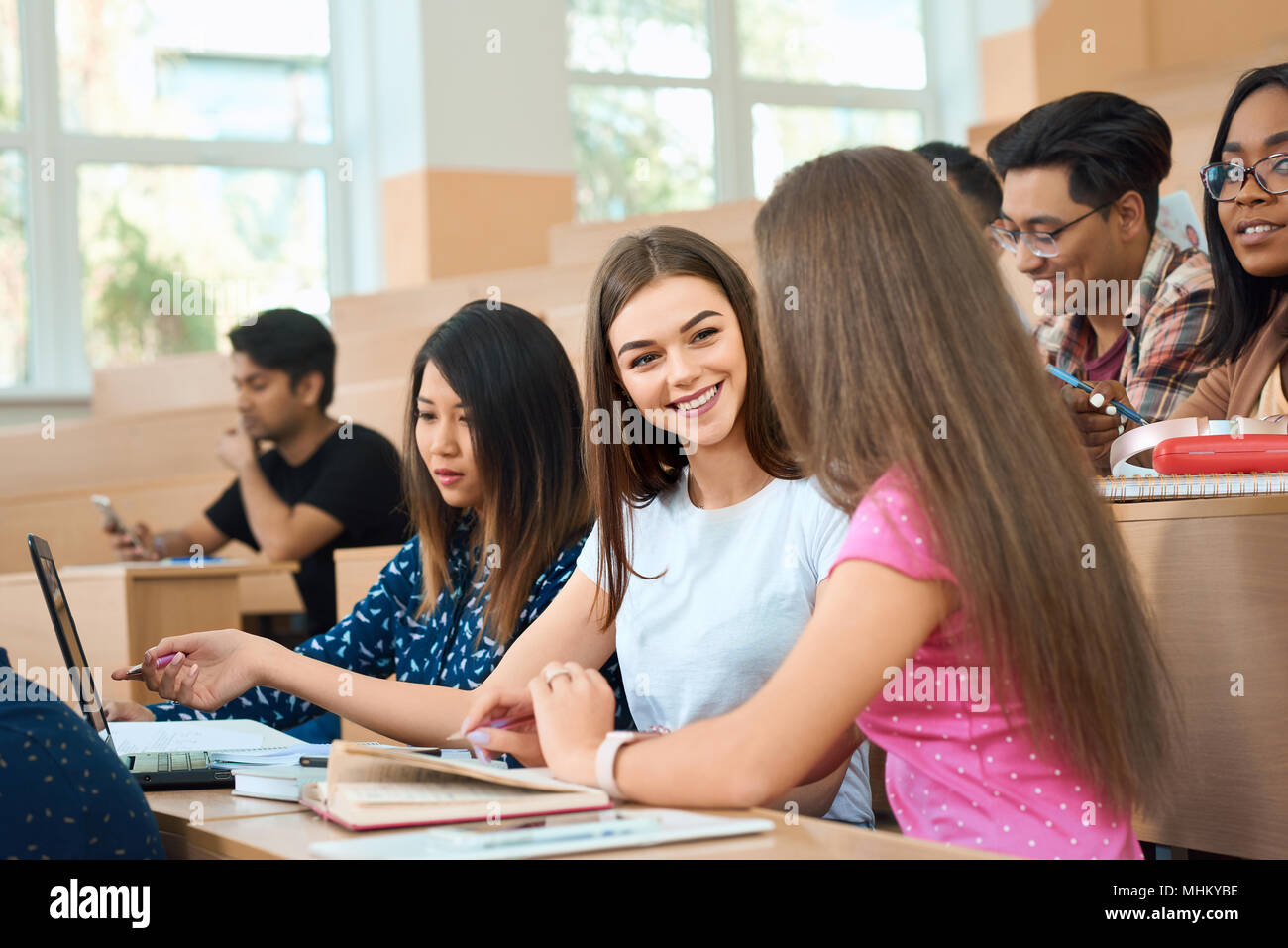 Sorridendo gli studenti a parlare durante la lezione. Seduto nella ...