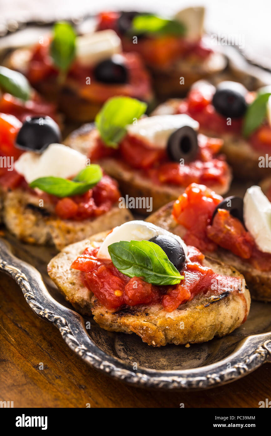 Pane tostato Bruschetta con mozzarella olive pomodori e basilico e olio ...