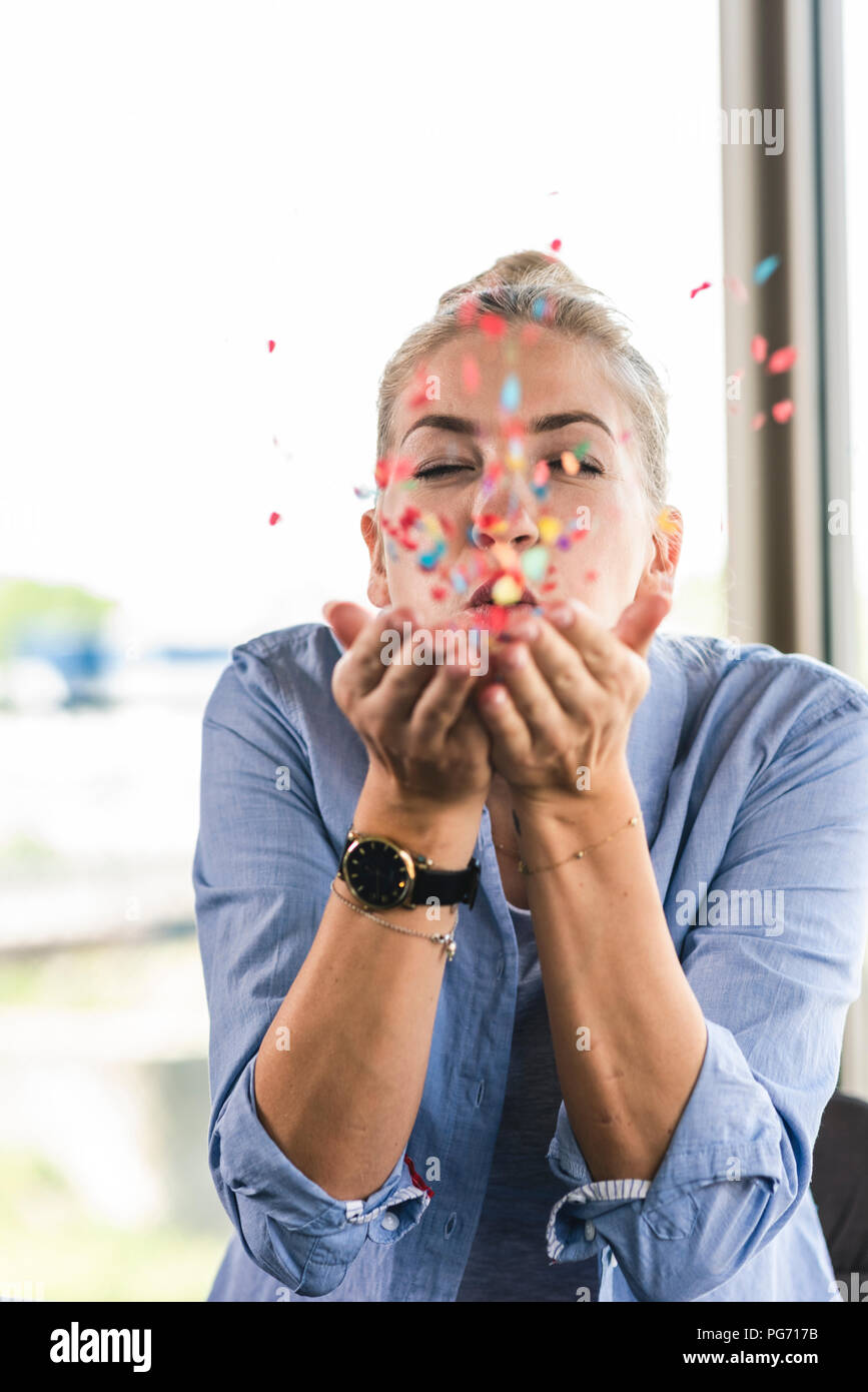 Felice imprenditrice soffiando coriandoli immagini e fotografie stock ...