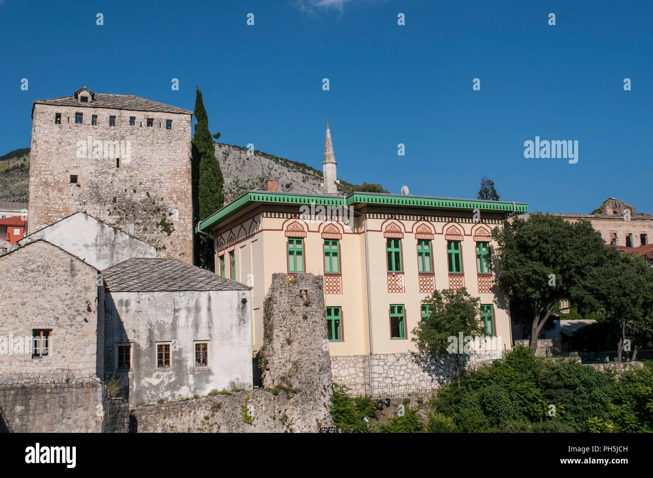 Bosnia: lo skyline della città di Mostar con un palazzo esempio di ...