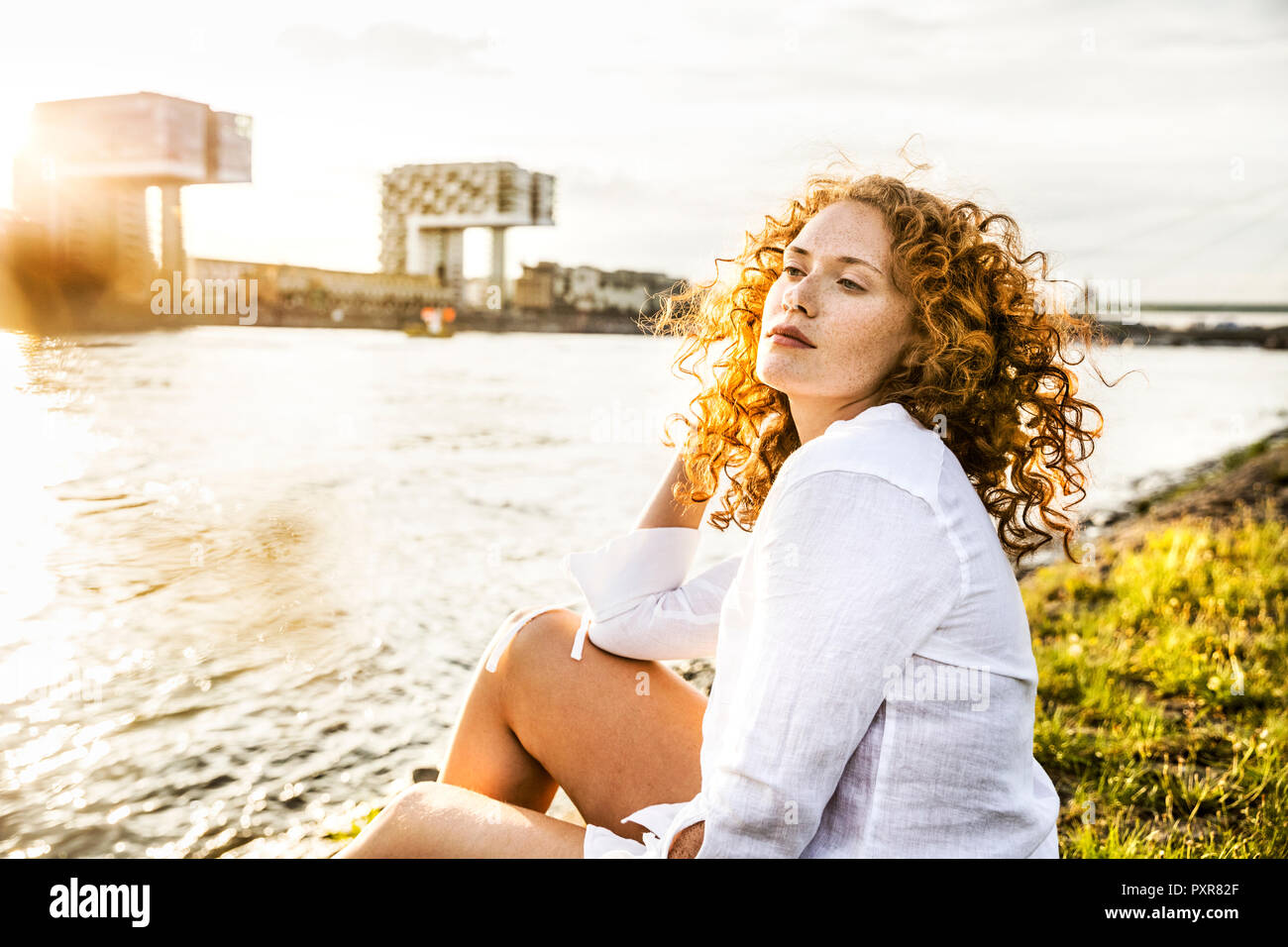 Ritratto di giovane donna seduta a riva del fiume in serata immagini e ...