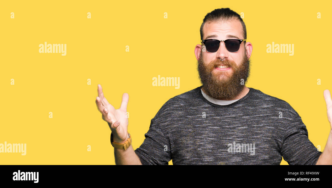 Tanga giovane uomo che indossa gli occhiali da sole e pazzo pazzo grida ...