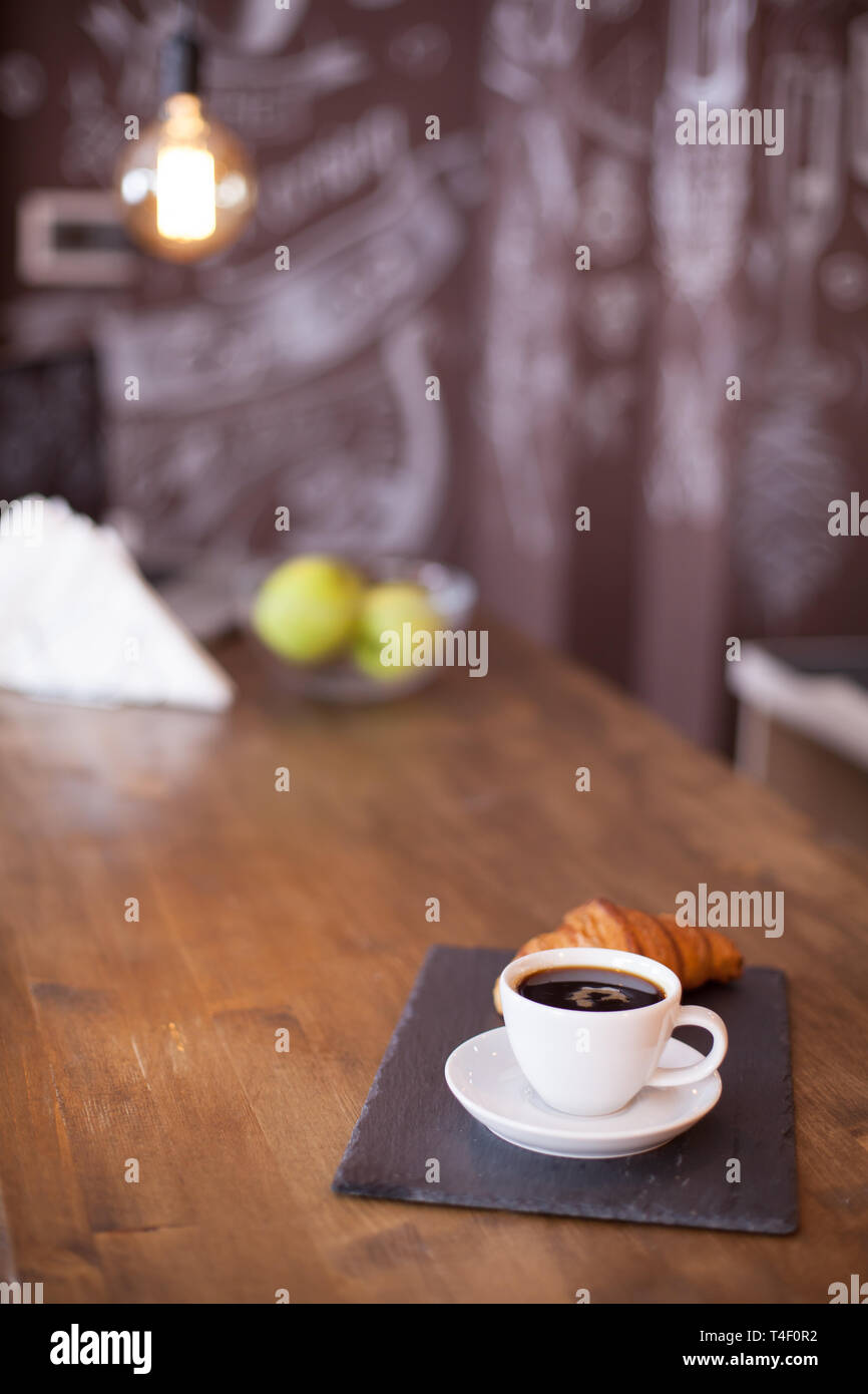 Nero caffè servito con deliziosi croissant con disegno sfocata in ...