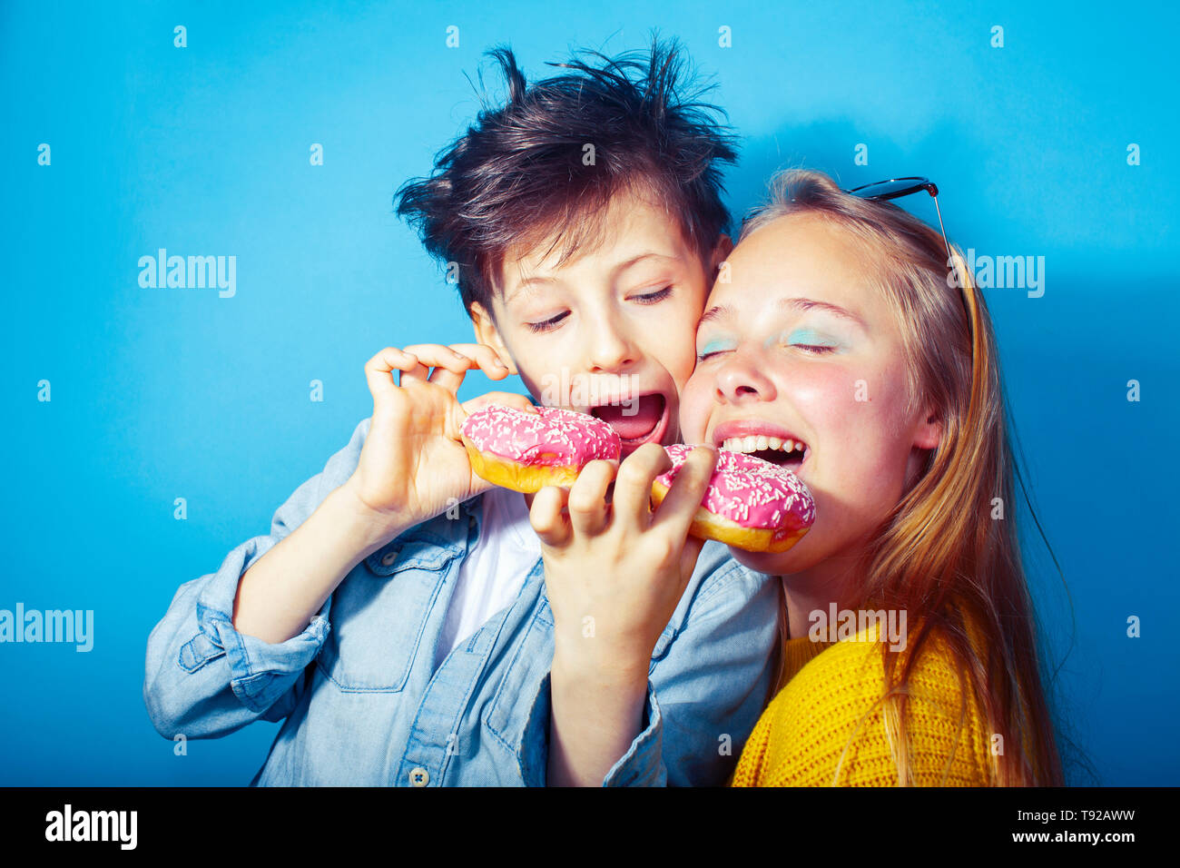 La famiglia felice del fratello e sorella di mangiare le ciambelle su ...