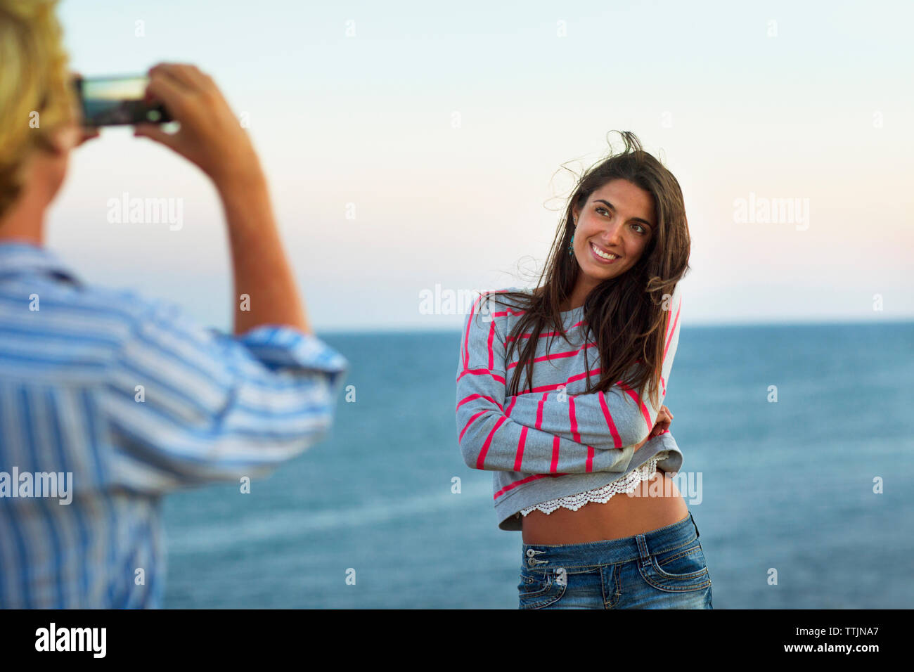 Uomo sorridente con le braccia incrociate in riva al mare immagini e ...