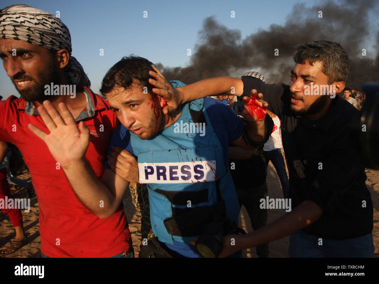 Dimostranti palestinesi evacuare feriti giornalista Mahmoud Bassam ...