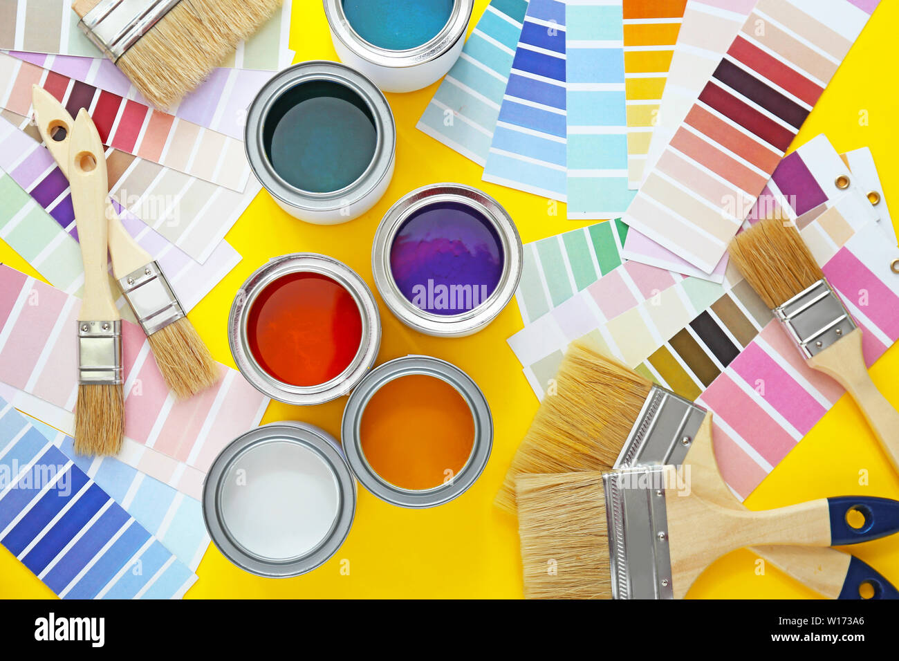 Le lattine di vernici con i pennelli e la tavolozza dei colori campioni ...