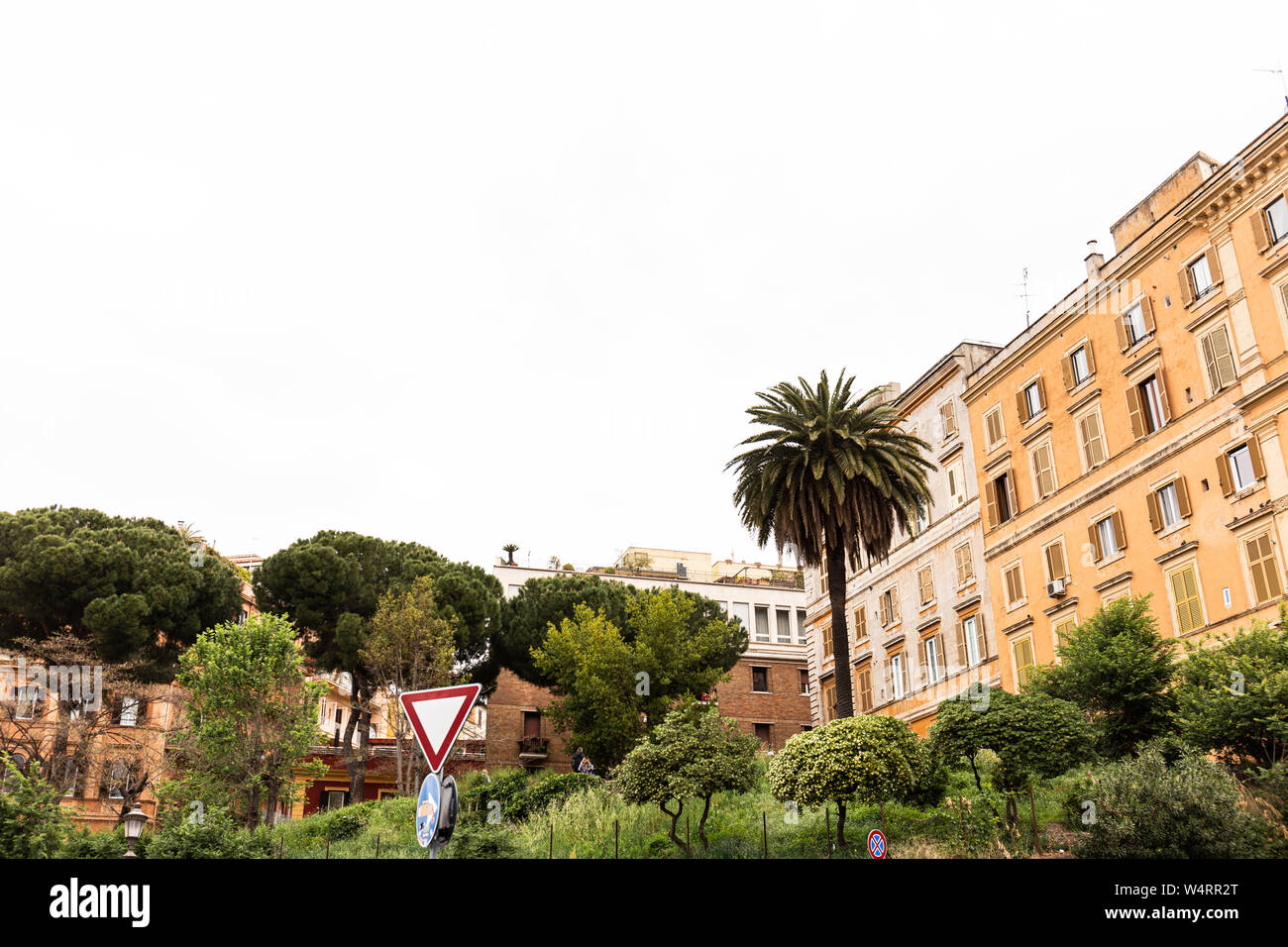 Cartello stradale, verdi alberi e cespugli vicino gli edifici colorati ...